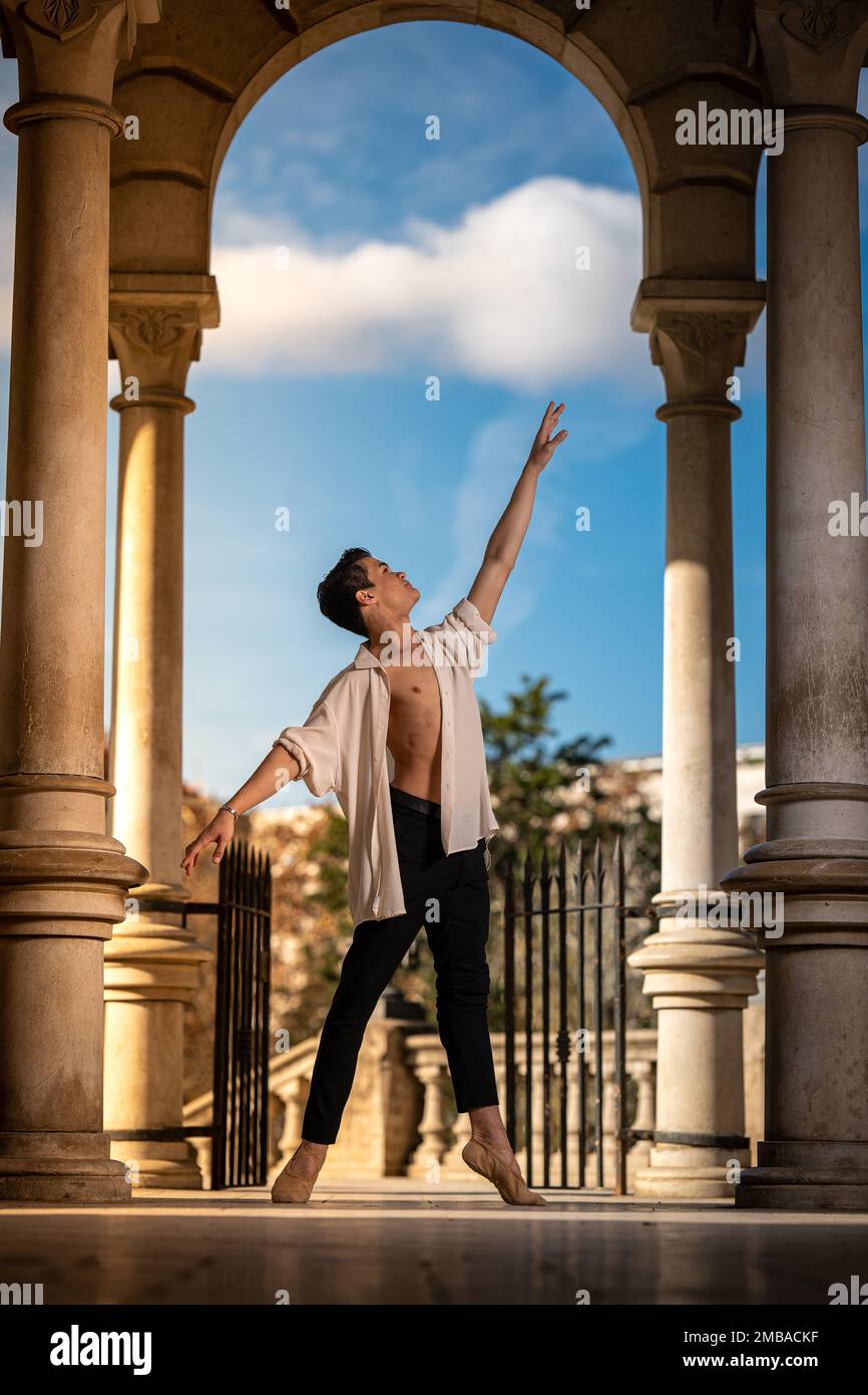 Young man dancing classic ballet in the streets of Barcelona with a ...