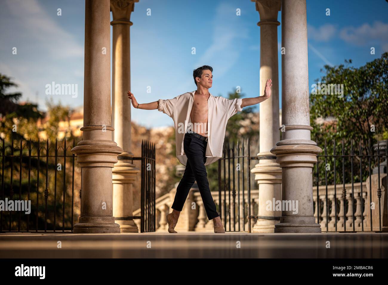 Young man dancing classic ballet in the streets of Barcelona with a ...