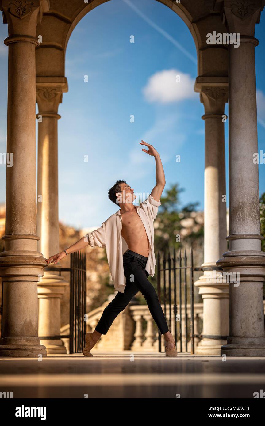 Young man dancing classic ballet in the streets of Barcelona with a ...