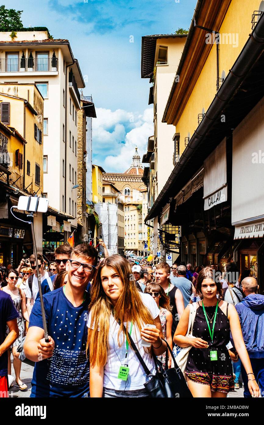 A young couple using a selfie stick to take a selfi in Florence ...