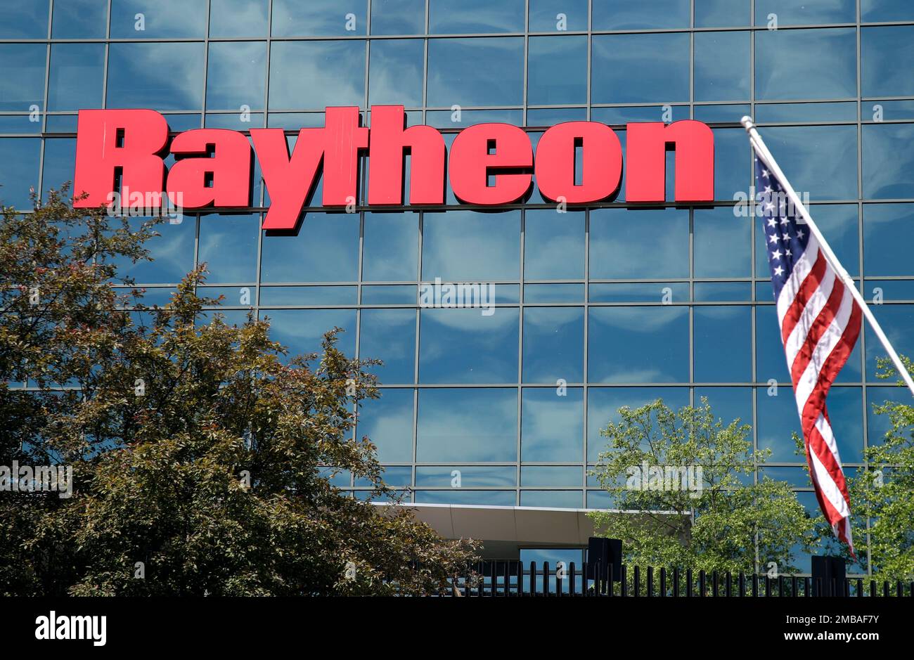 FILE - An American flag flies in front of the facade of Raytheon's ...