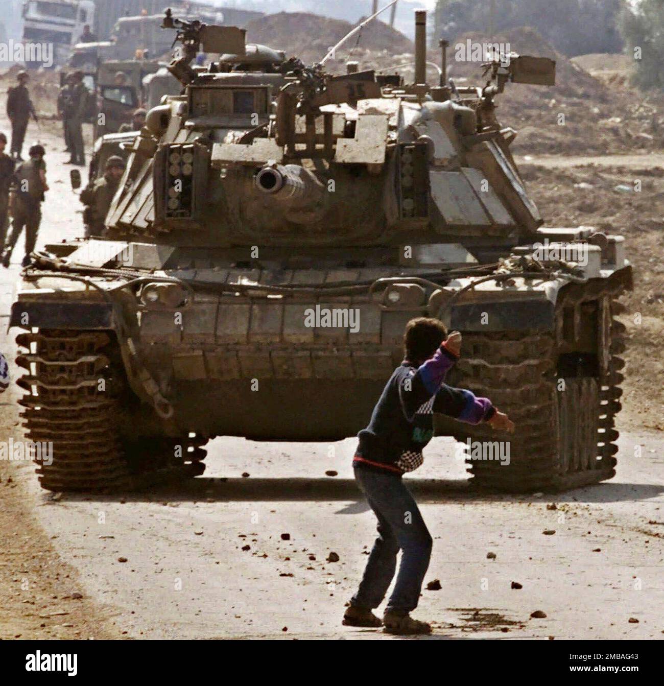 FILE - A Palestinian stone thrower faces an Israeli tank during clashes ...