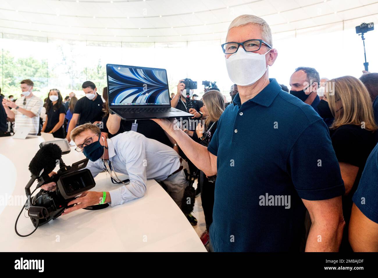 Apple CEO Tim Cook poses for photos as he holds one of the new Apple ...