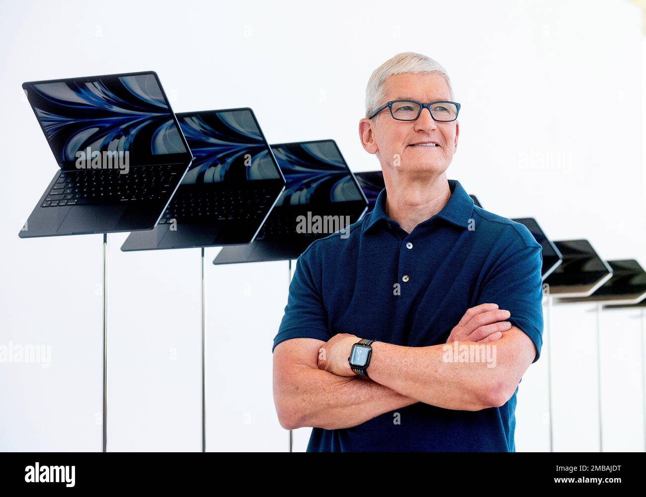 Apple CEO Tim Cook stands in front of a display of new Apple MacBook ...