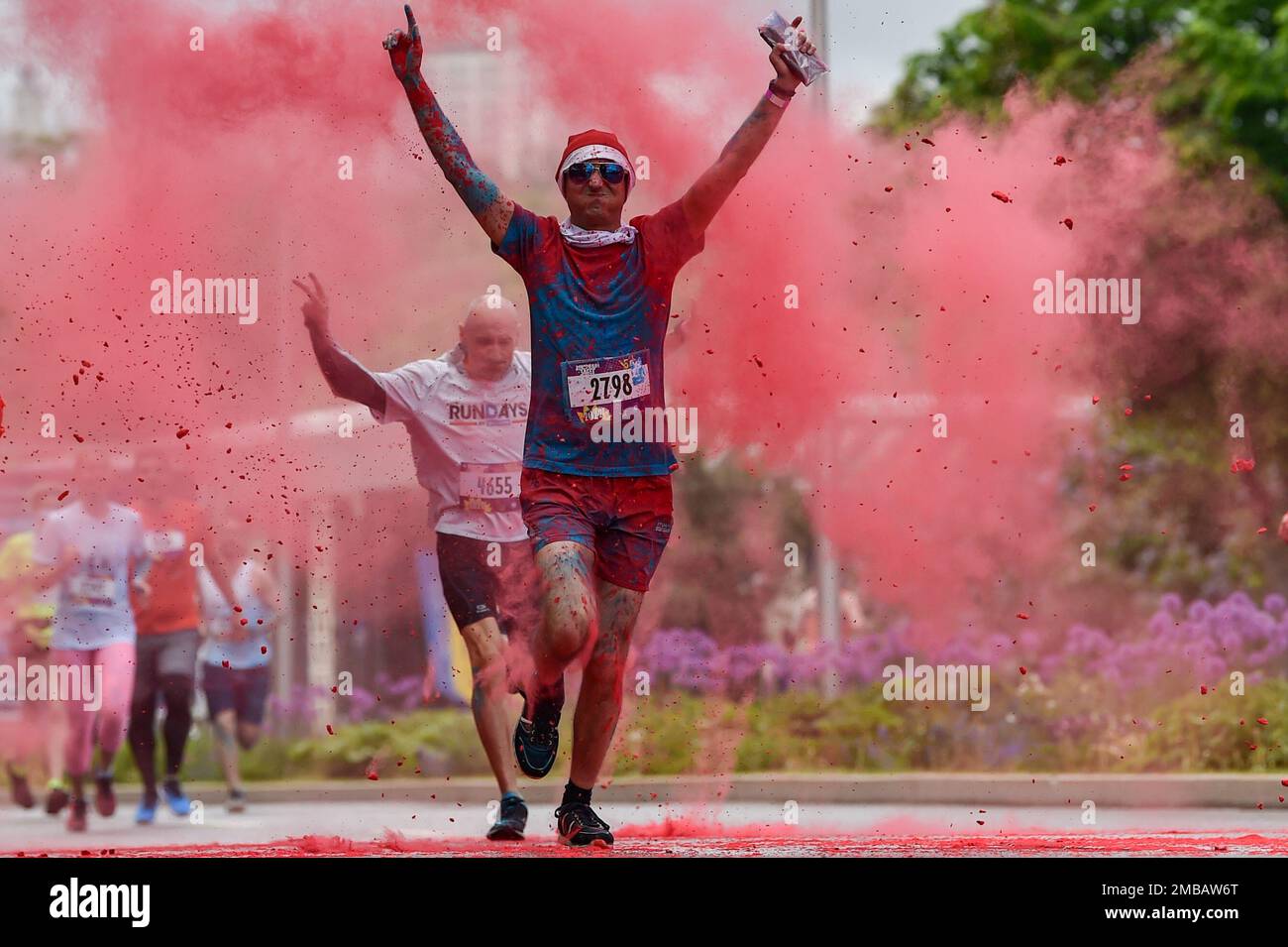 Runners are covered in coloured paint powder as they compete in the 5 ...