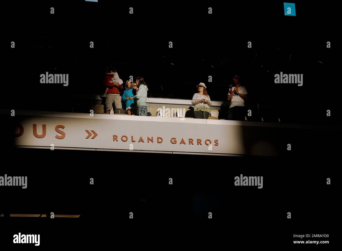 The setting sun illuminates a few spectators during the men's doubles ...