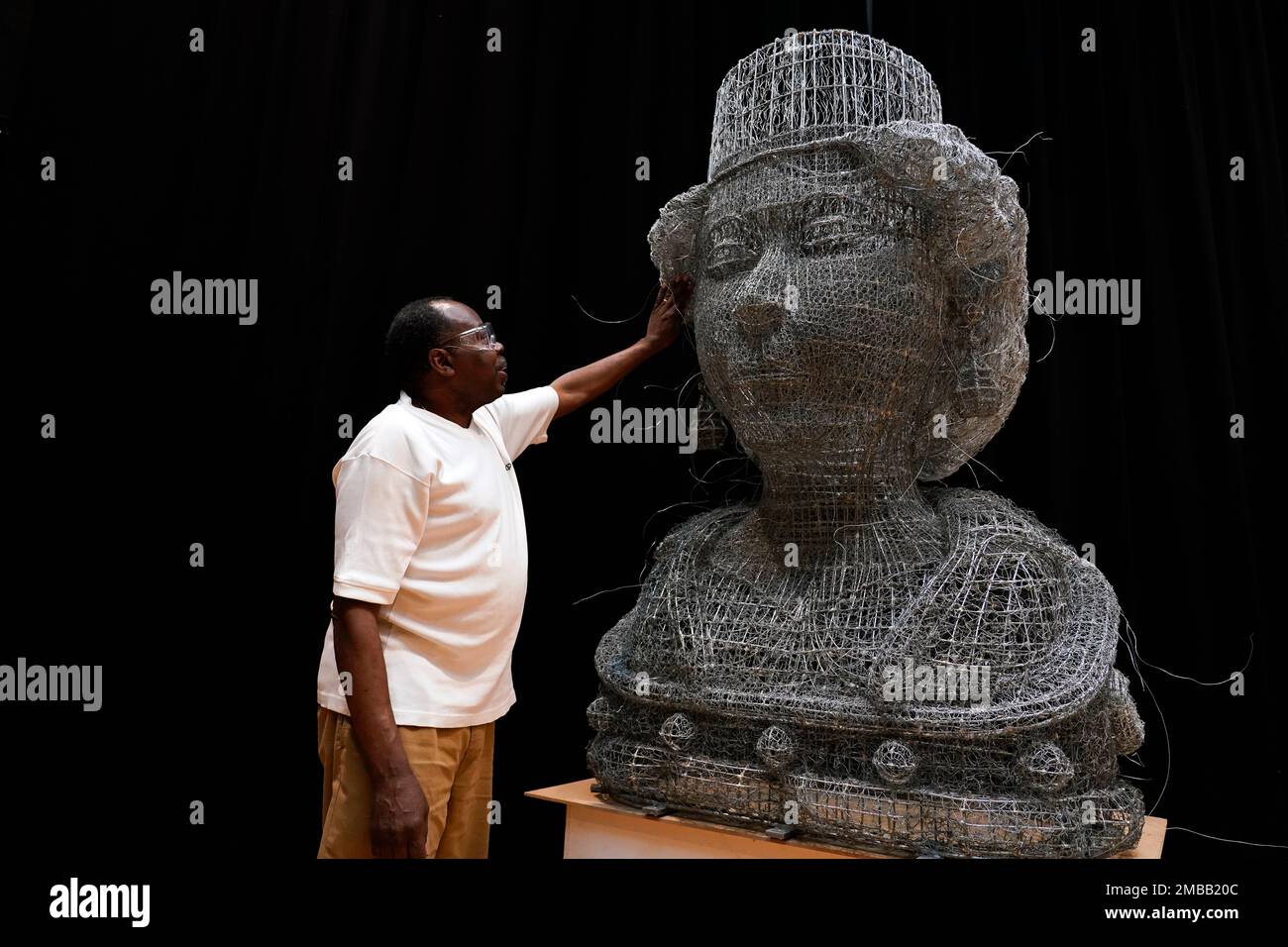 Artist Carl Gabriel touches his sculpture made of wire depicting the ...