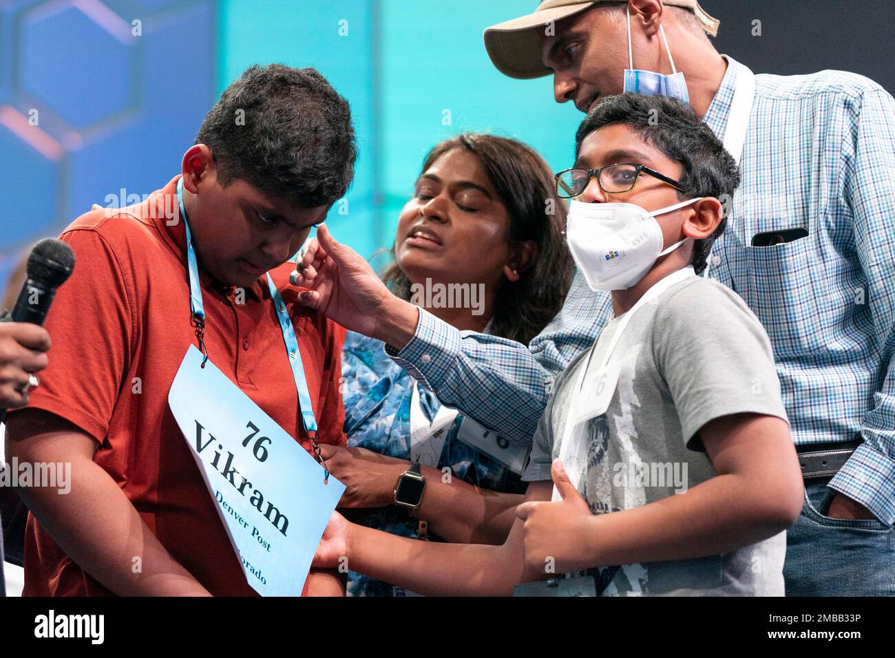 Vikram Raju, 12, from Aurora, Colo., left, is consoled by her family ...
