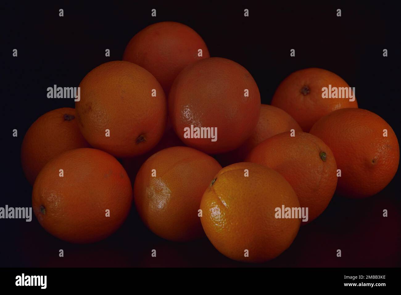 Multiple fresh oranges arranged together in black background. Ready to ...