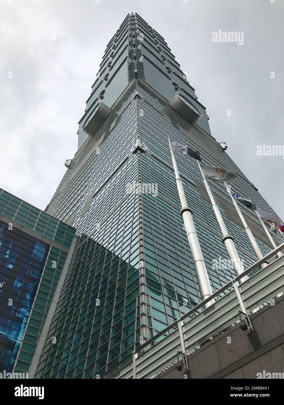 A vertical low angle shot of a tall modern glass tower in Taiwan Stock ...