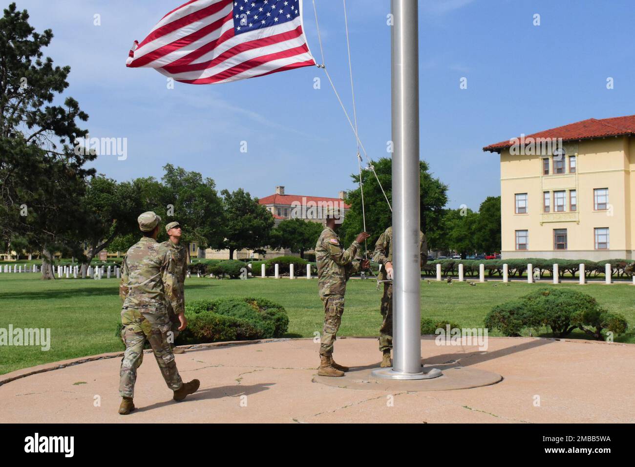 Spc. Luis Perez and Pfc. Alberto Campos prepare to collect the flag as ...