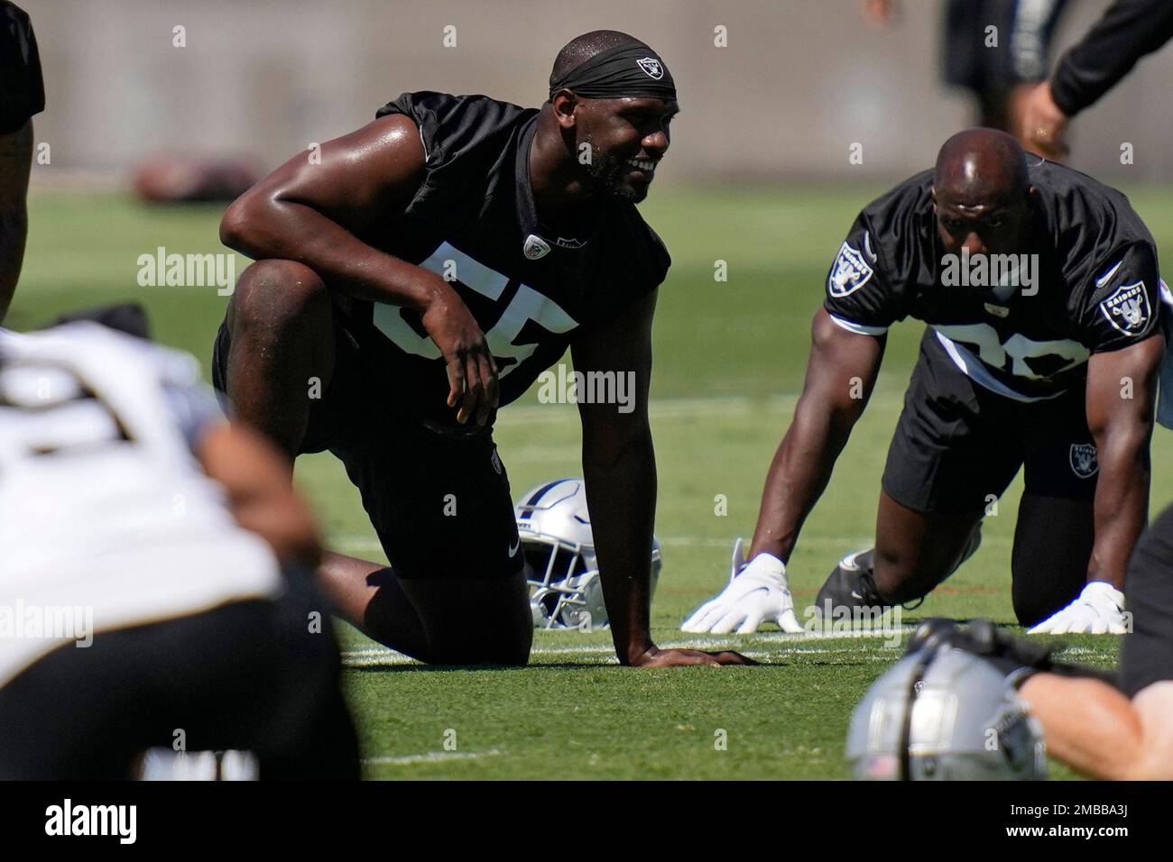 Las Vegas Raiders defensive end Chandler Jones, left, warms up during ...