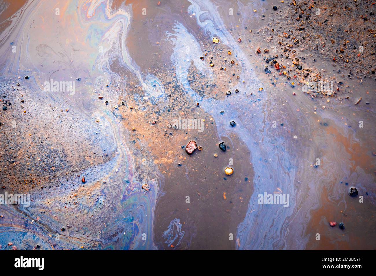 Colorful gasoline stain on the background of polluted water in a puddle ...