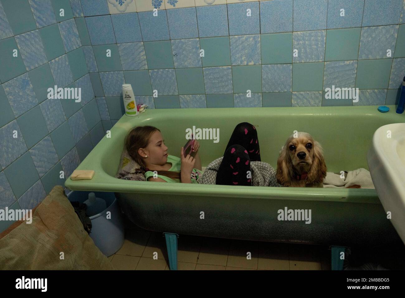 Zlata-Maria Shlapak sits with her puppy Letti in the bathtub while an ...