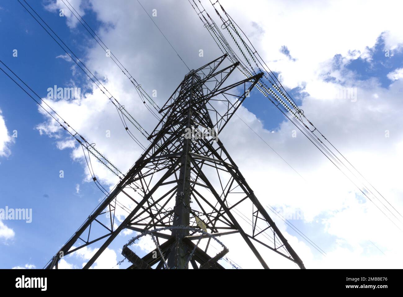 Pylon and wires against blue sky with white clouds Stock Photo - Alamy