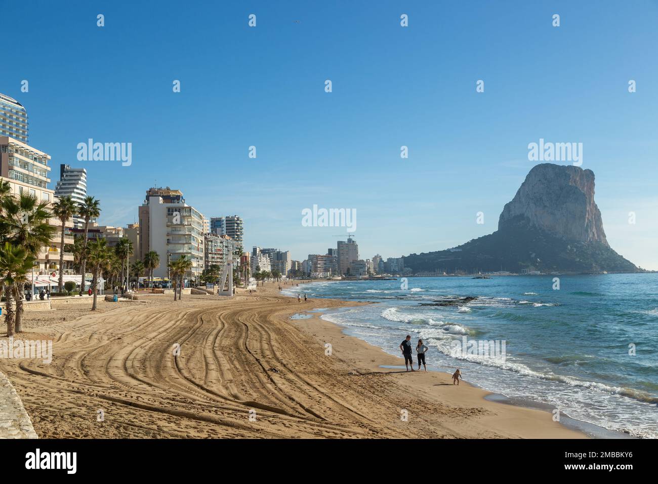Beach and seafront promenade at Calpe, Spain. Penon de Ifach in ...