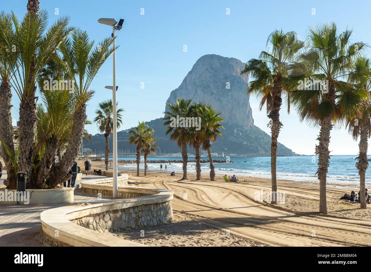 Beach and seafront promenade at Calpe, Spain. Penon de Ifach in ...