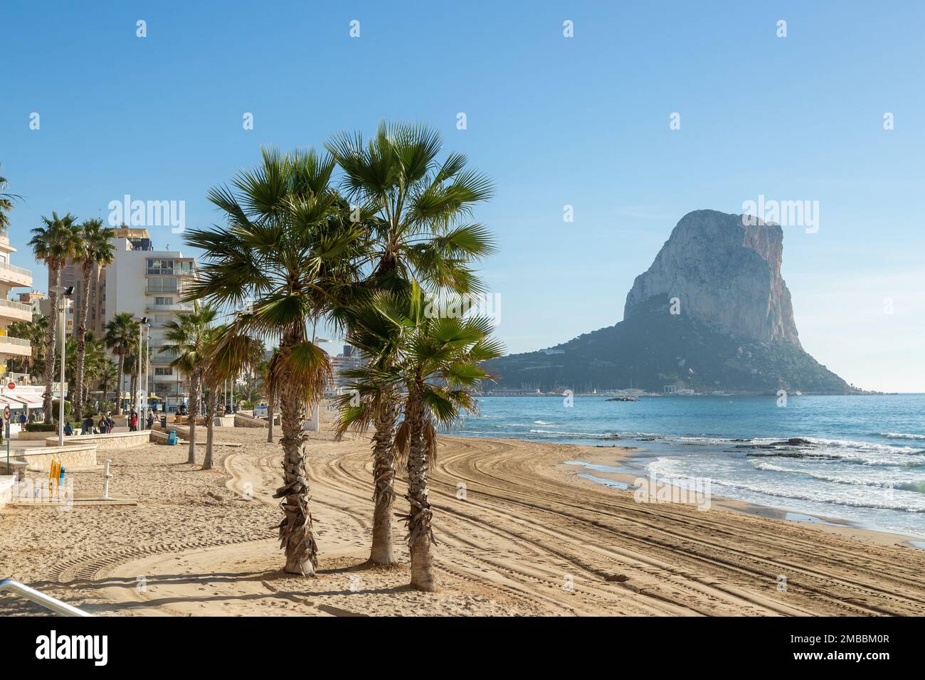 Beach and seafront promenade at Calpe, Spain. Penon de Ifach in ...