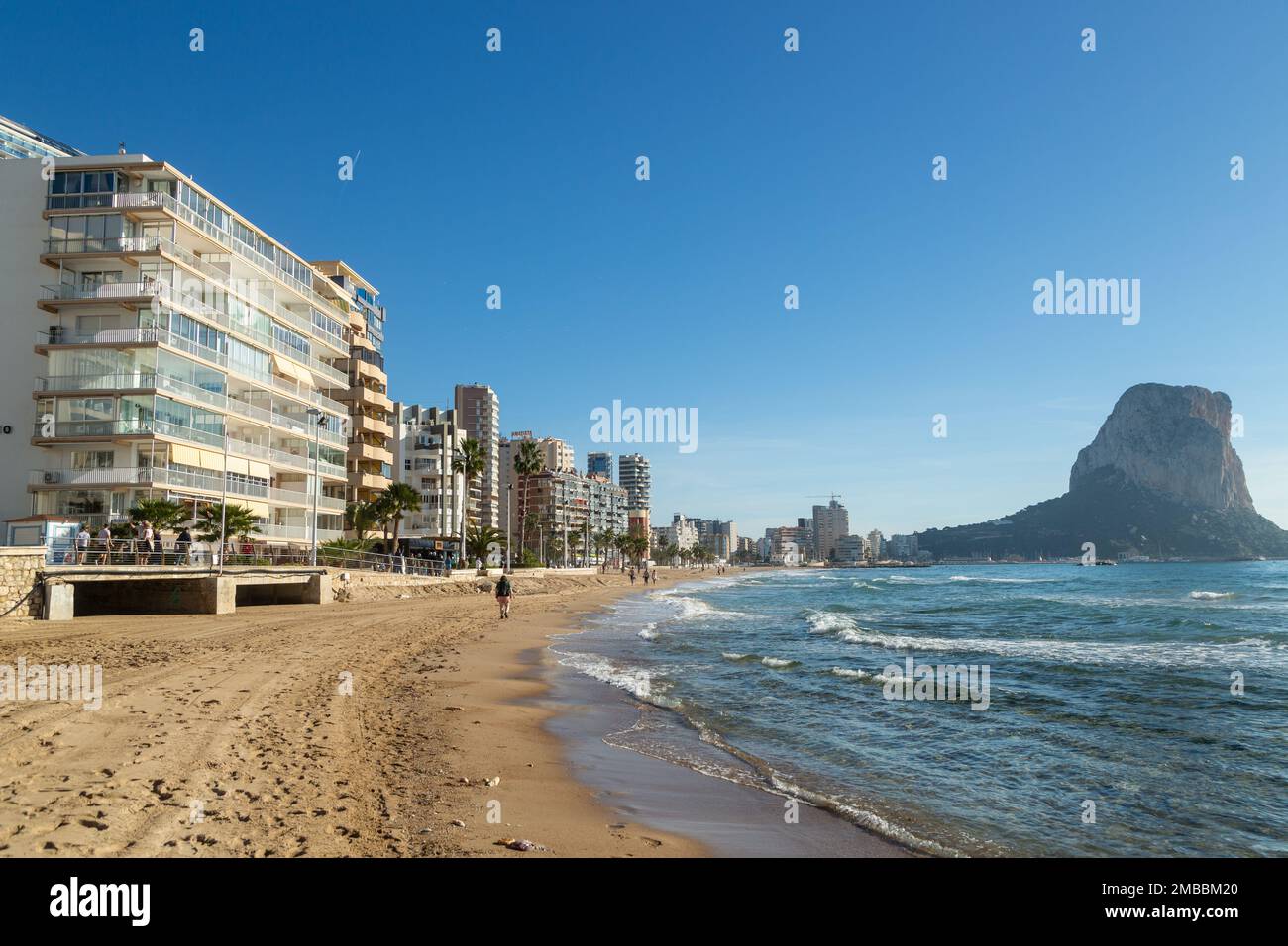 Beach and seafront promenade at Calpe, Spain. Penon de Ifach in ...