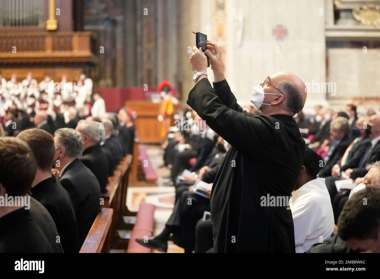A participant into the funerals for late Cardinal Angelo Sodano snaps a ...