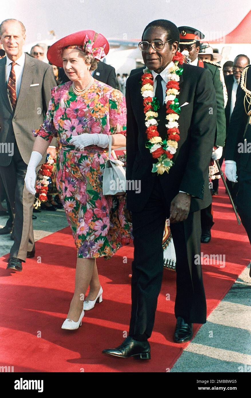 FILE - Britain's Queen Elizabeth II is escorted by Zimbabwean President ...