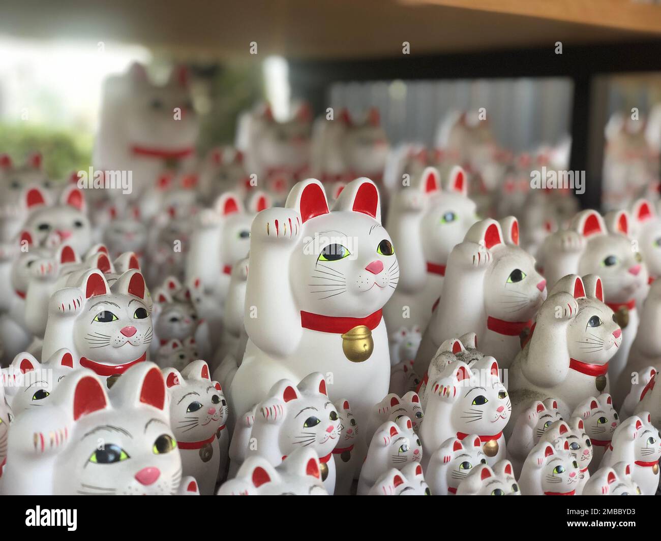 A pile of cute Japanese Maneki Neko cat figurines of different sizes ...