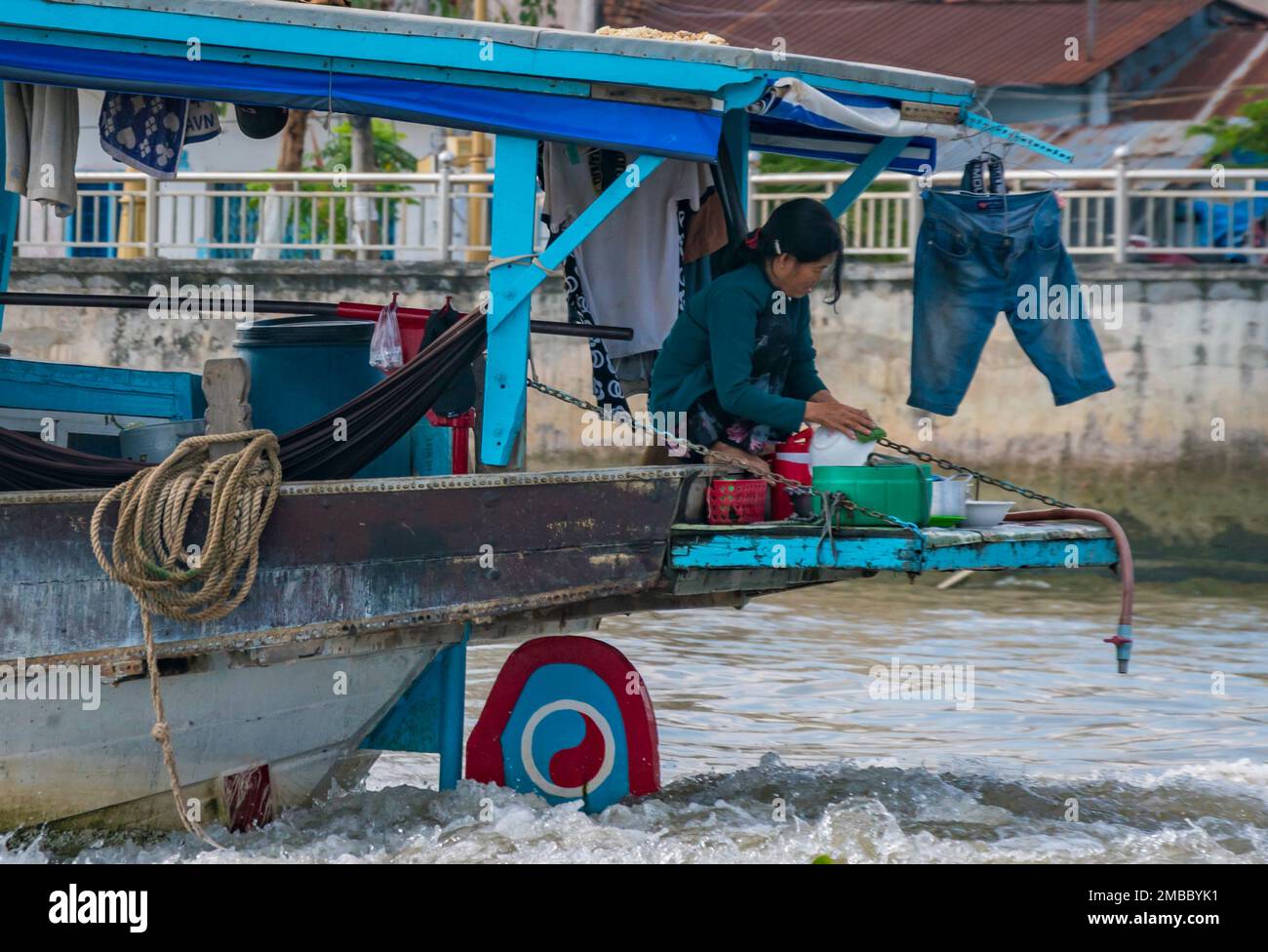 woman on a boat house with washing hanging and drying Stock Photo - Alamy