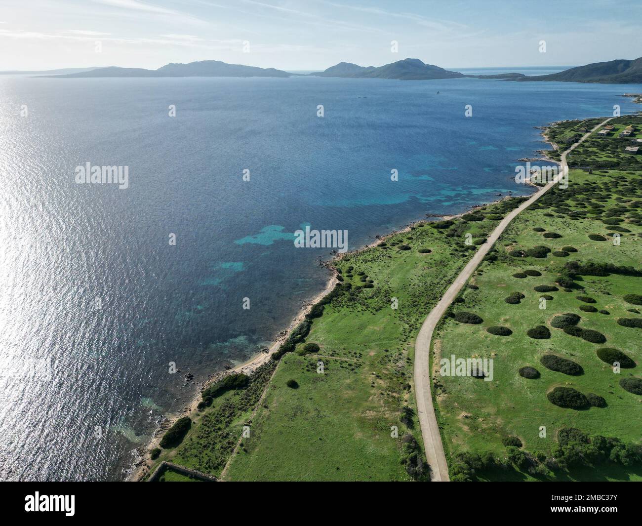 An aerial view of lush green shore of an island and ocean with coral ...