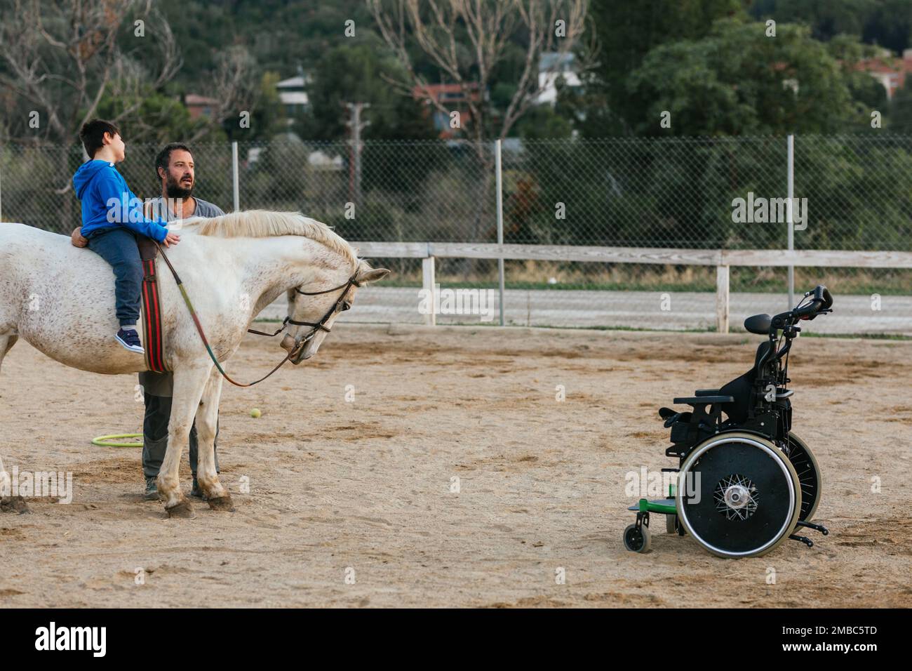 boy with disability riding a horse next to wheelchair Stock Photo - Alamy