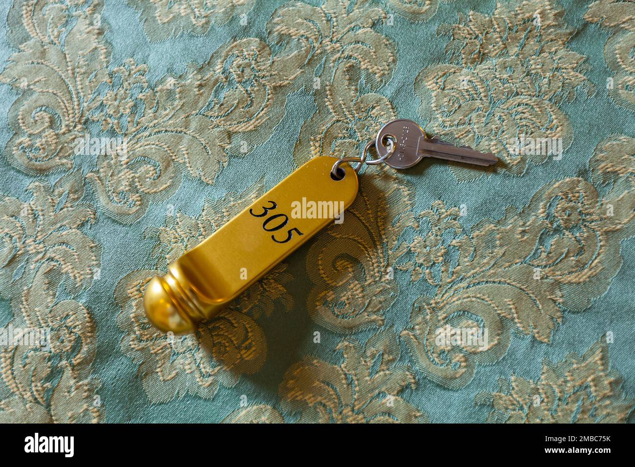 Room key on brocade bedspread Stock Photo - Alamy