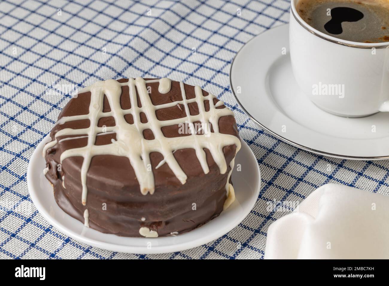 Brown chocolate alfajor, typical candy in Argentina, with a cup of ...