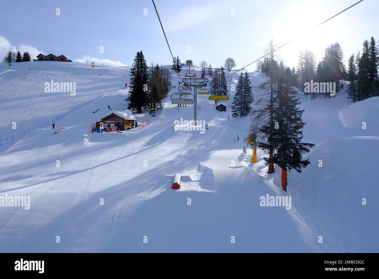 Ski lift above snow park on a sunny day in Alta Badia area, Dolomites ...