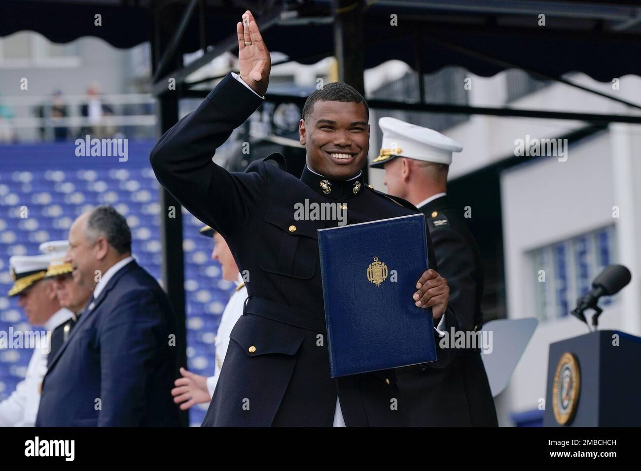 A graduate celebrates receiving a diploma during the U.S. Naval Academy ...