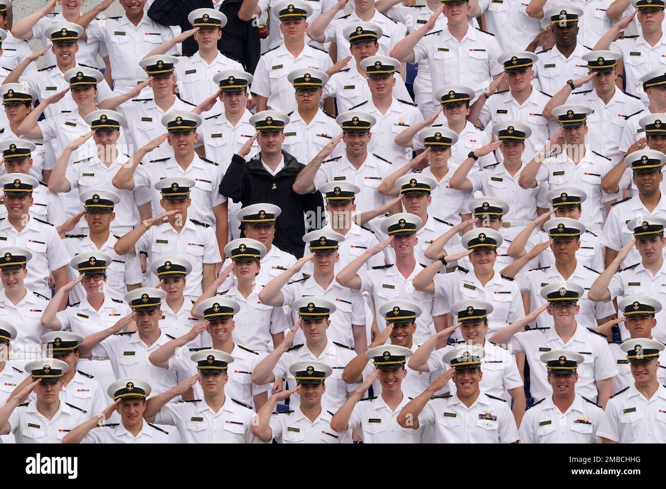 Undergraduate midshipmen salute as they watch the U.S. Naval Academy's ...