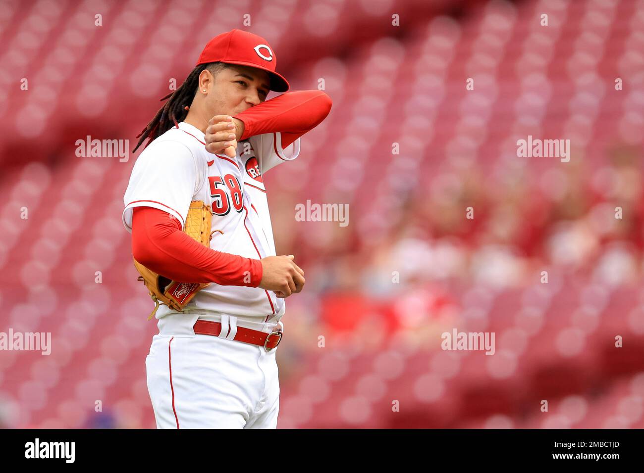 Cincinnati Reds' Luis Castillo wipes his face between pitches during a ...