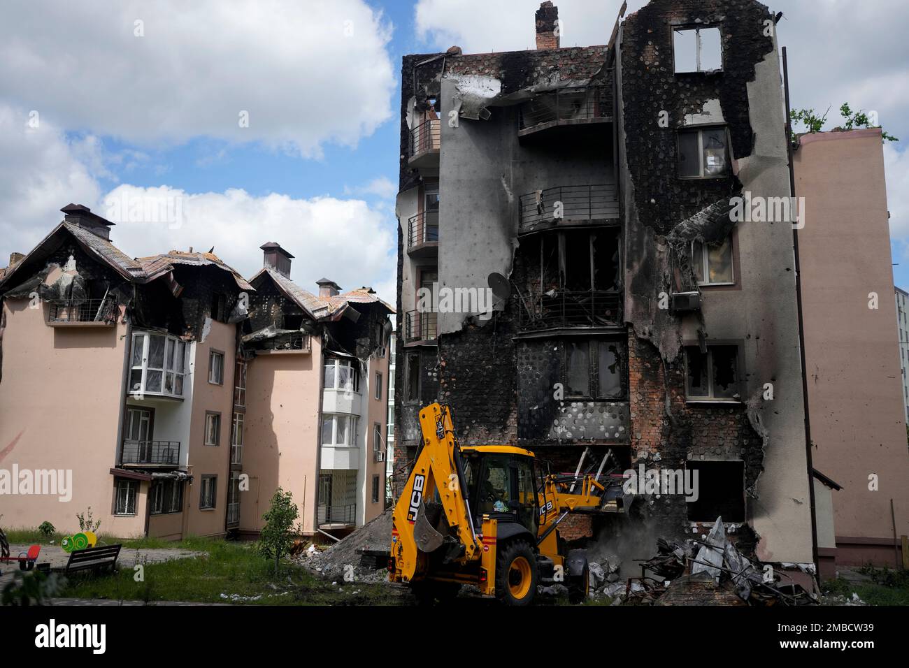 An excavator removes the debris at a damaged building ruined by attacks ...