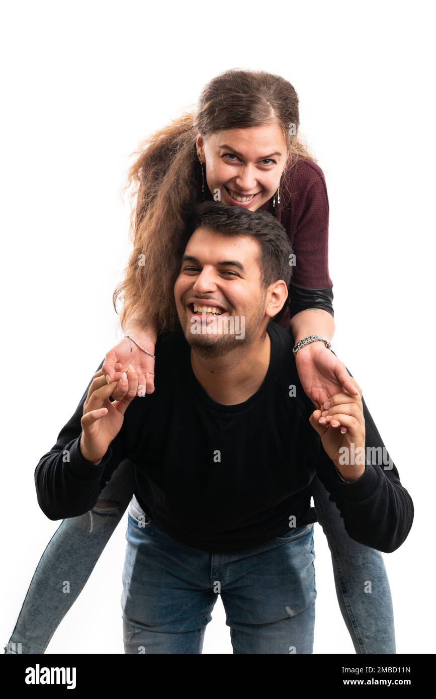 Adult girlfriend jumping on boyfriend back holding hands with joyful ...