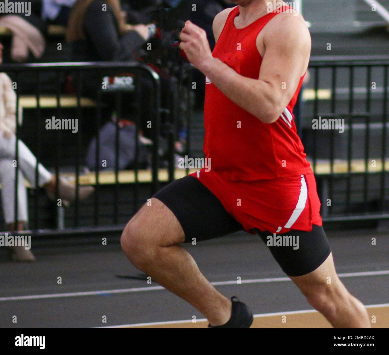 Close up of a high school sprinter runner racing on an indoor track in ...