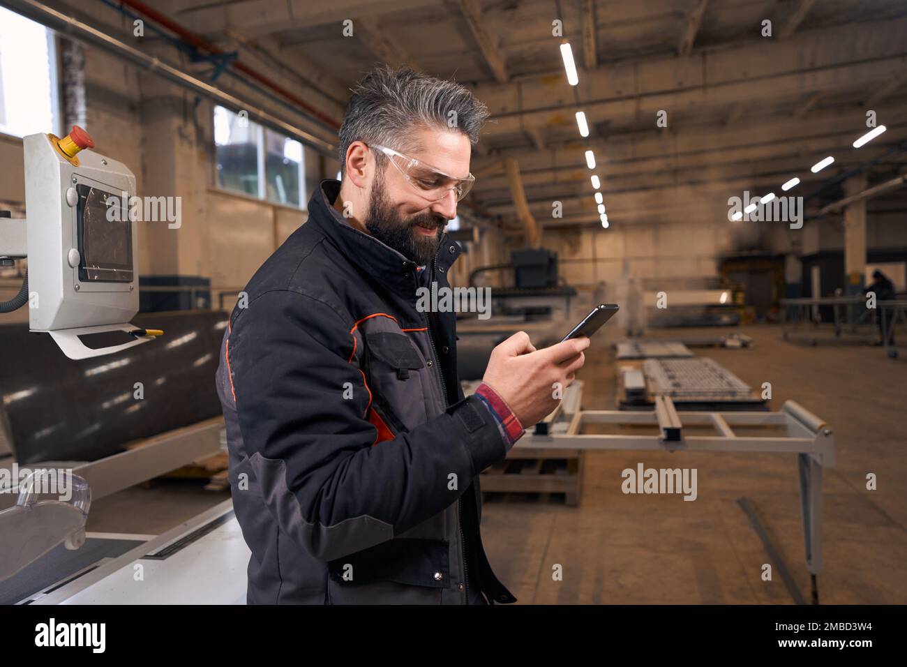 Portrait of man holding mobile phone at work Stock Photo - Alamy