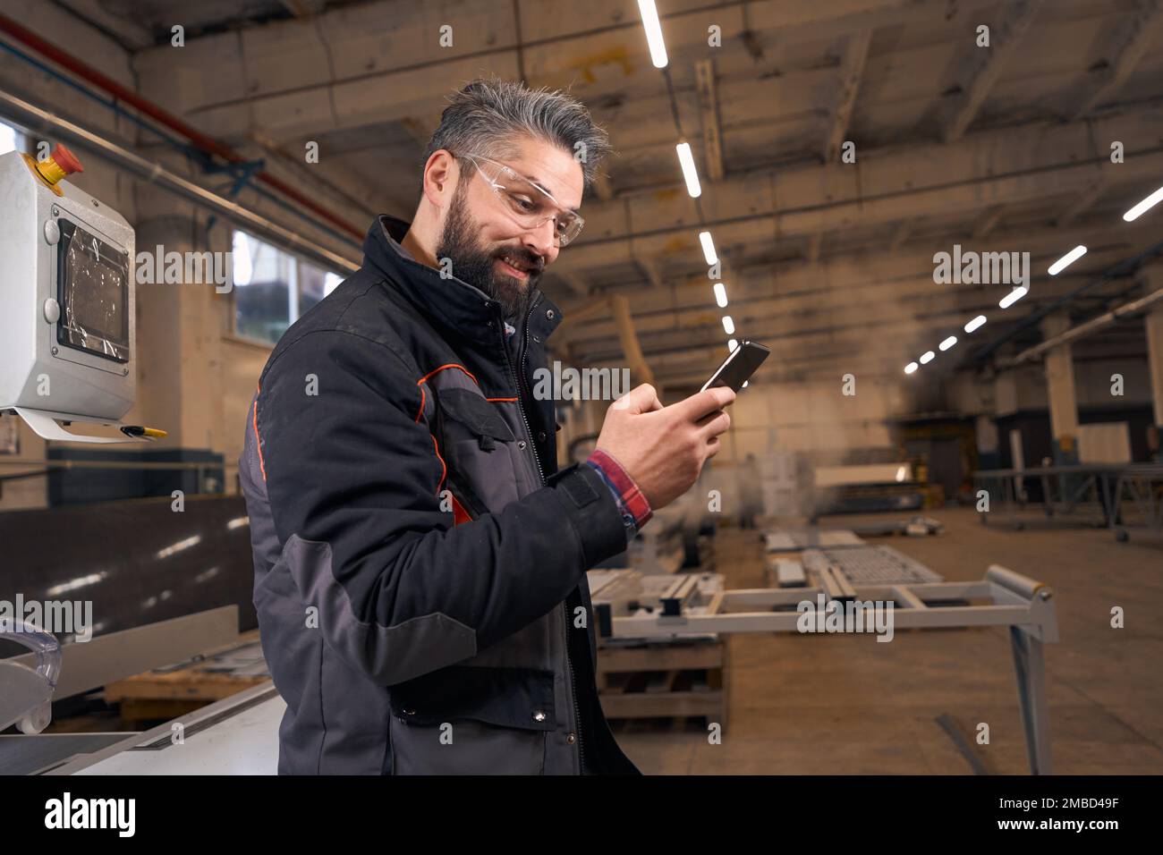 Portrait of worker holding mobile phone at work Stock Photo - Alamy