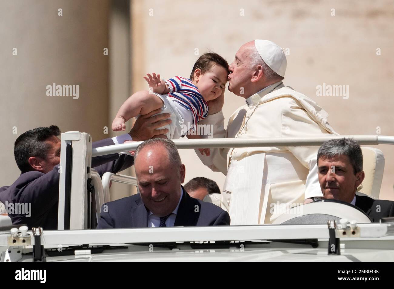 Pope Francis kisses a baby as he leaves at the end of his weekly ...