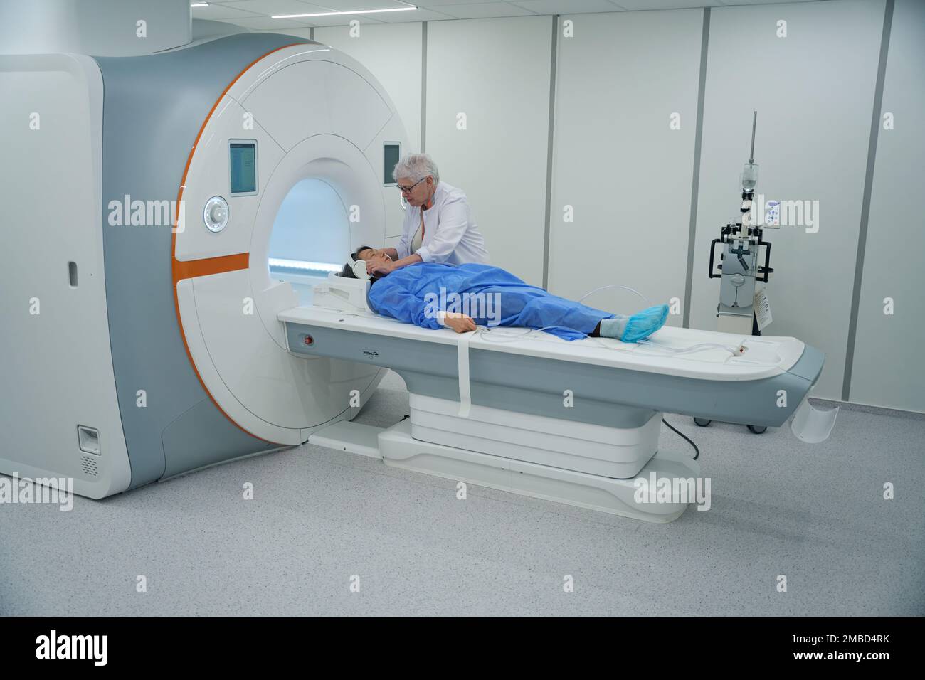 Woman diagnostician prepares a patient for an MRI procedure Stock Photo ...