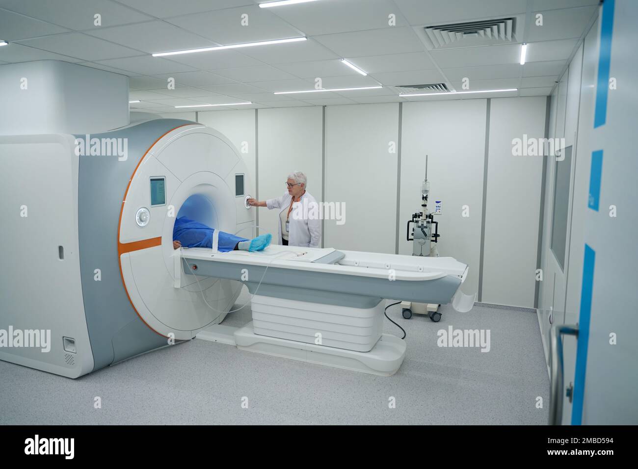 Elderly diagnostician examines a patient on an MRI machine Stock Photo ...