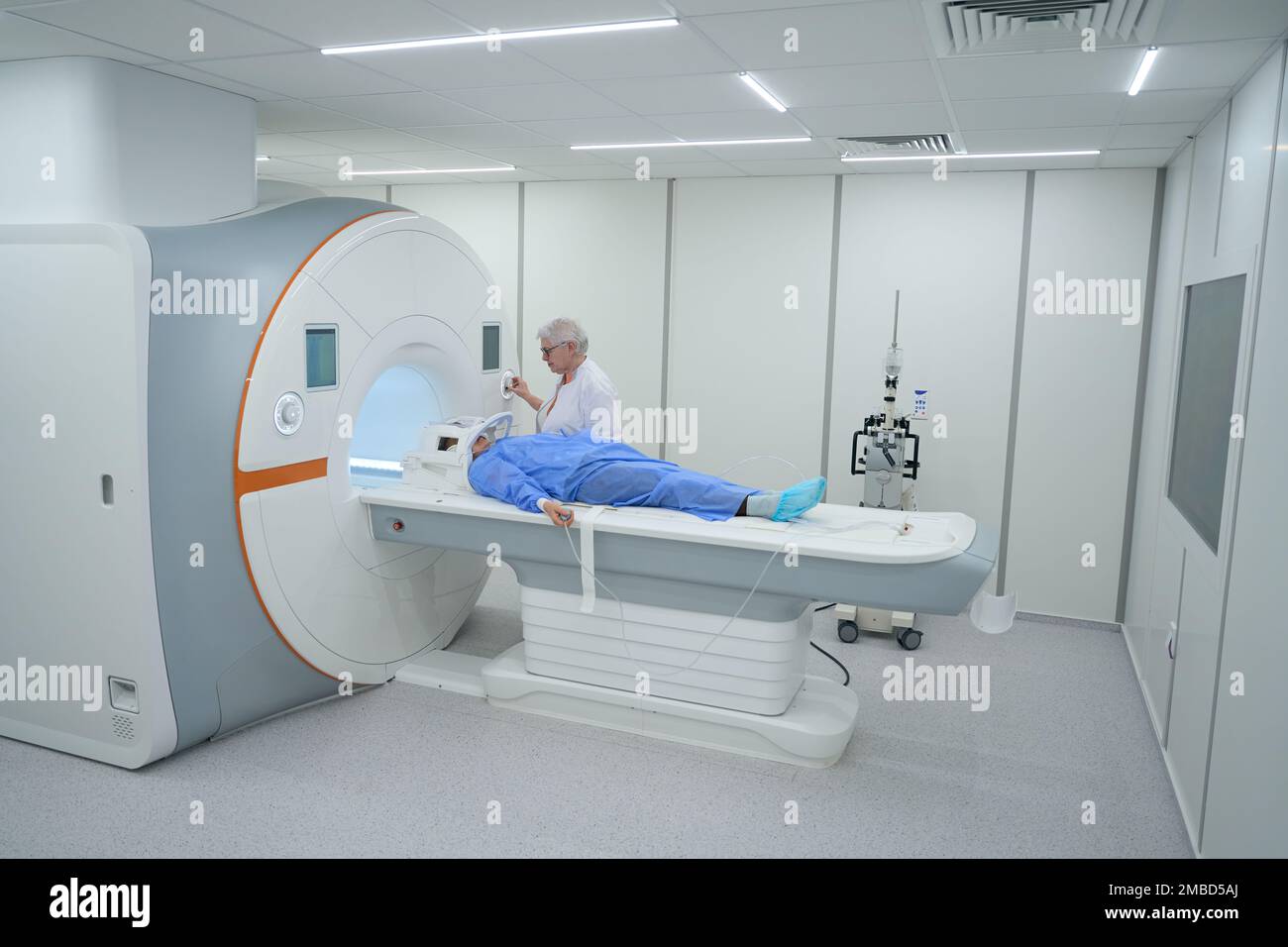 Woman diagnostician examines a patient on an MRI machine Stock Photo ...
