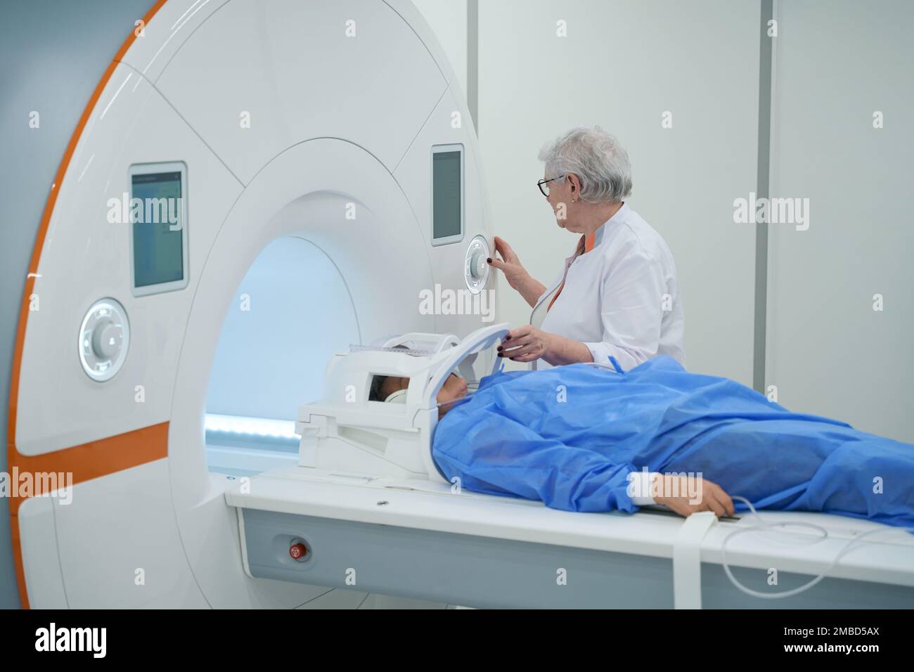 Doctor diagnostician sets up the MRI machine to examine patient Stock ...