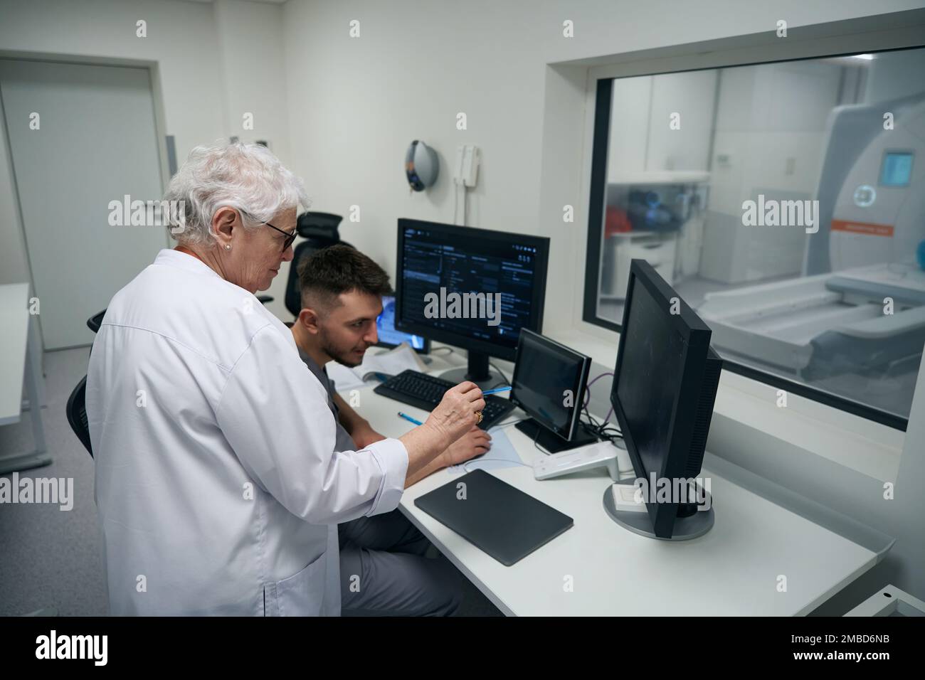 Colleagues diagnosticians perform MRI of the brain Stock Photo - Alamy
