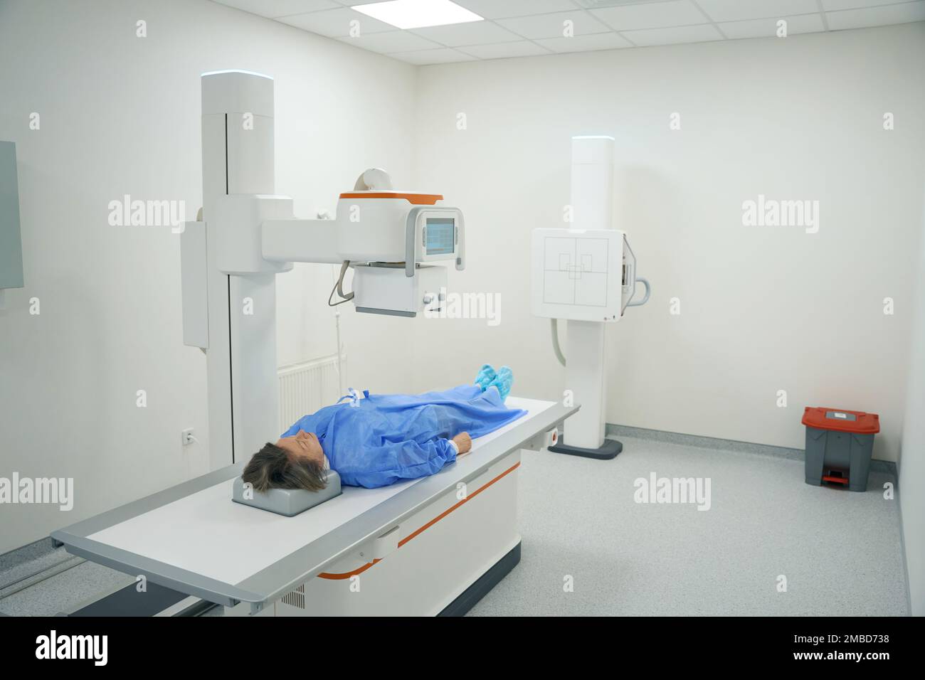 Patient undergoes an x-ray diagnostic procedure on modern equipment ...