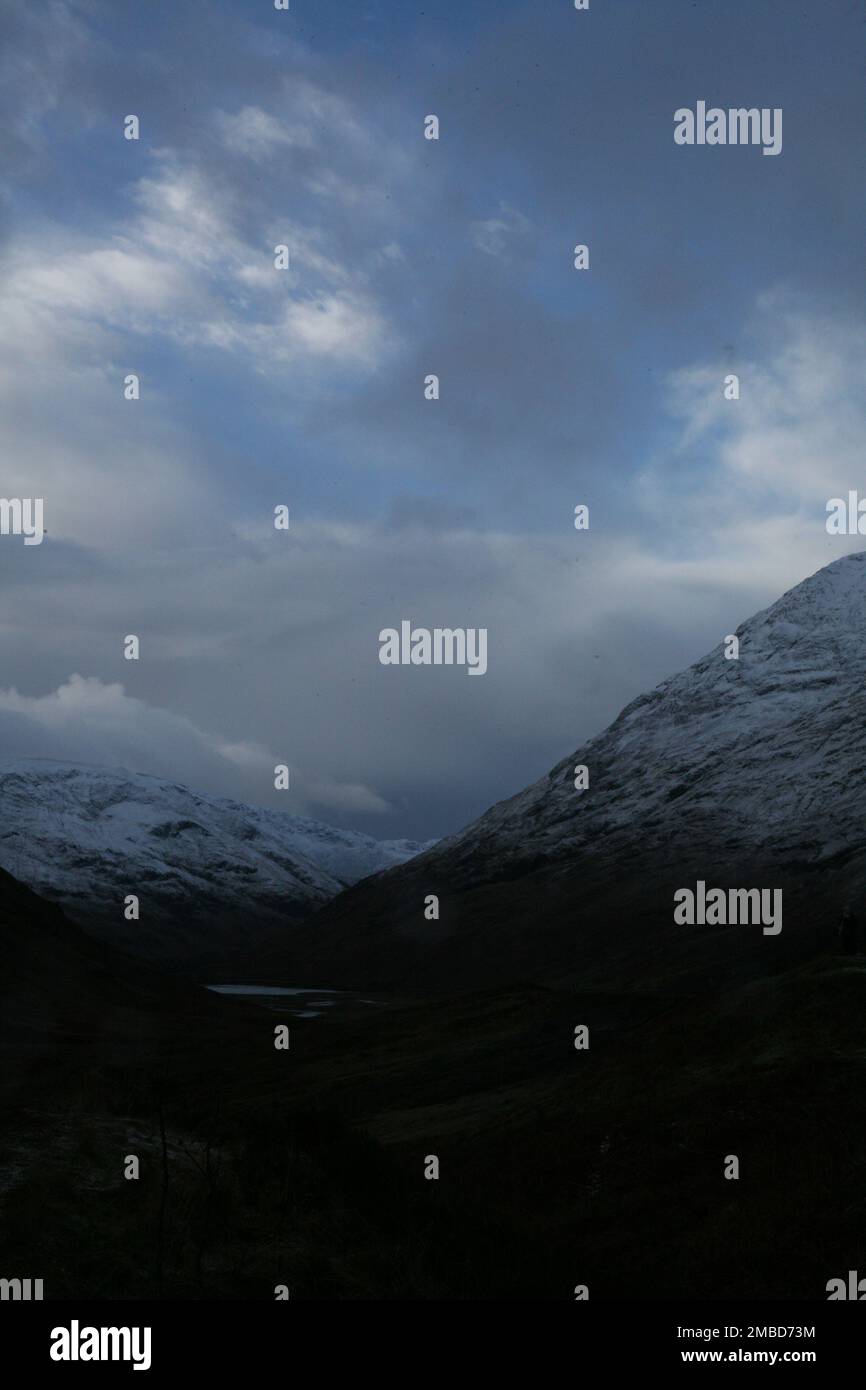 A vertical shot of snowy peak with cloudy sky Stock Photo - Alamy