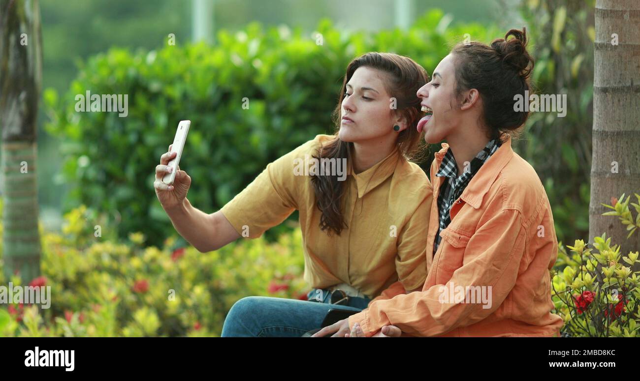 Two friends taking photo selfie with smartphone outdoors. Millennial ...