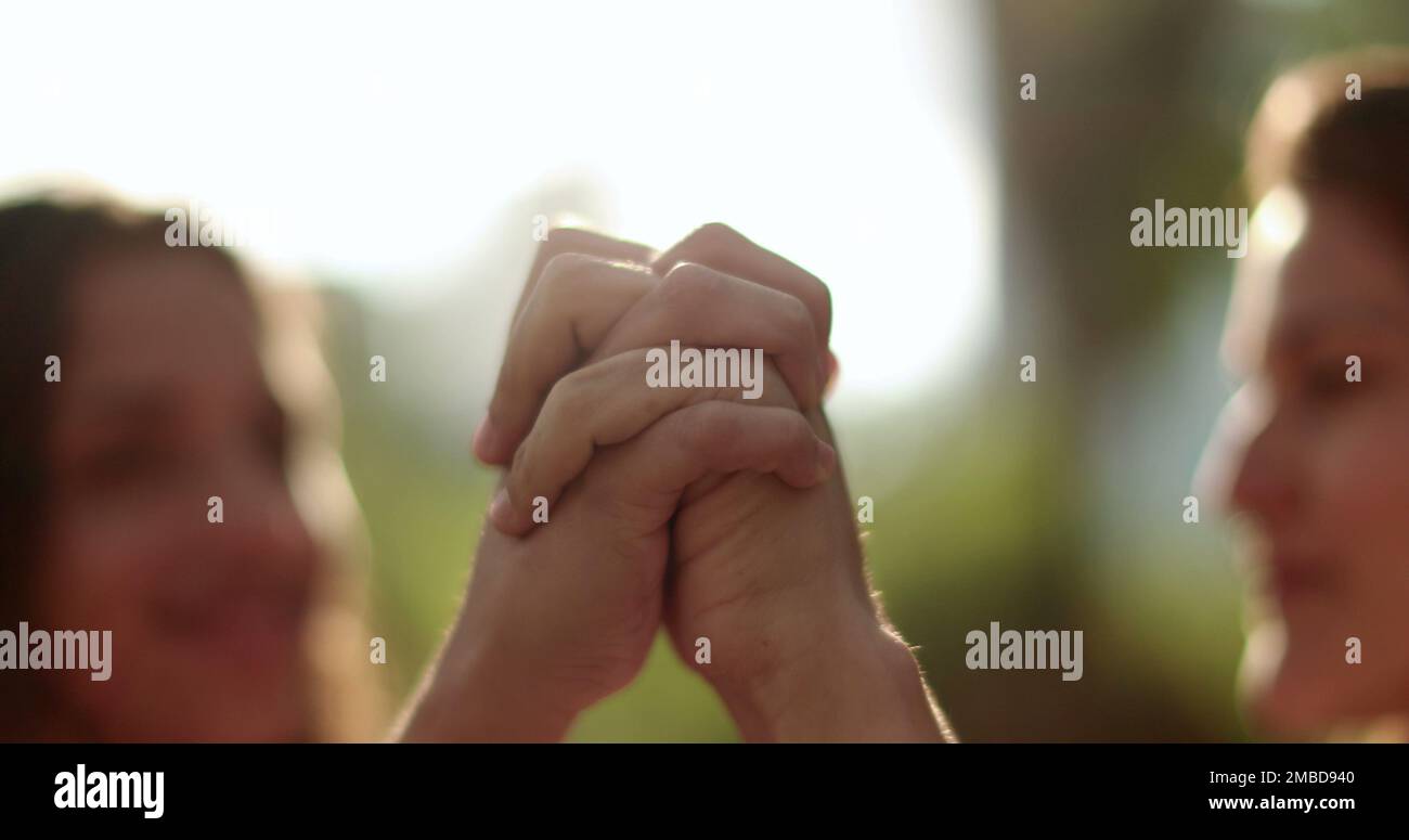 Two people joining hands in union outdoors. Teamwork concept symbol ...